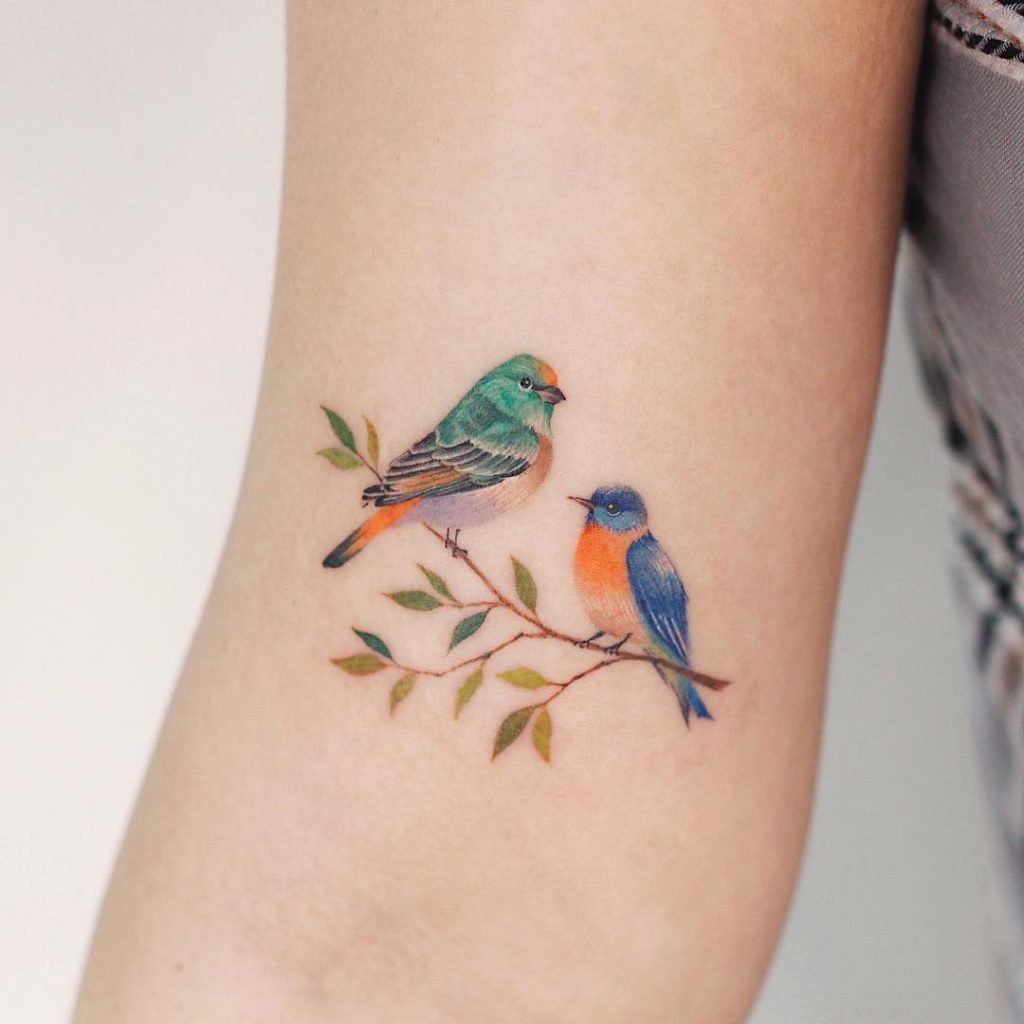 Colorful bird tattoo on the arm - Tattoogrid.net